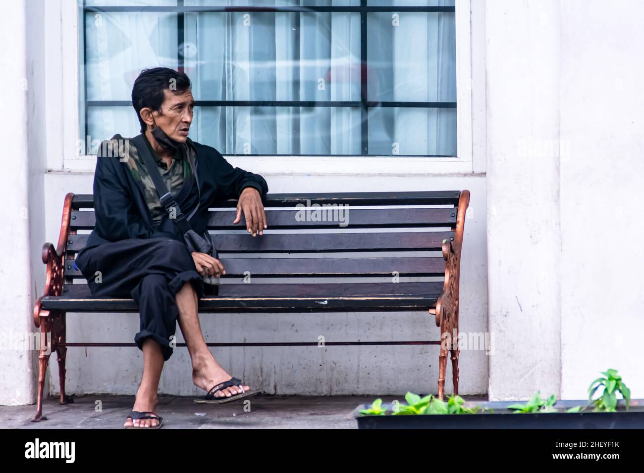 Local old men sitting on the public bench on the white vintage building ...