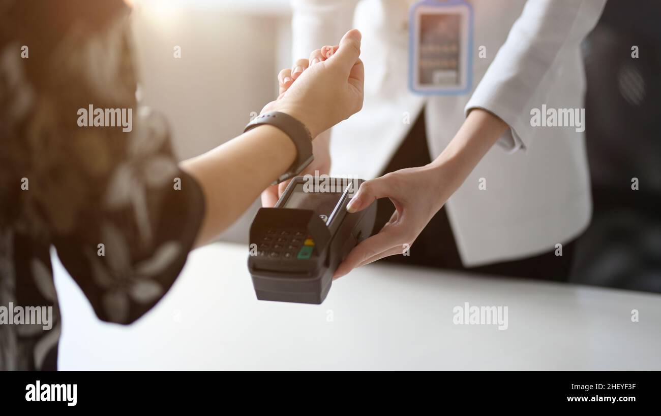 Male customer using his smart watch to pay his bills with terminal ...