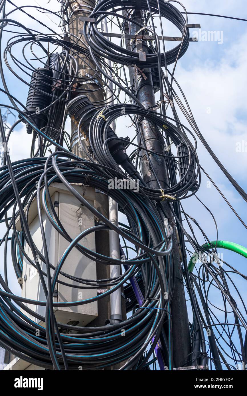 Mess cables rolled on the electric city pole under the clear and bright ...