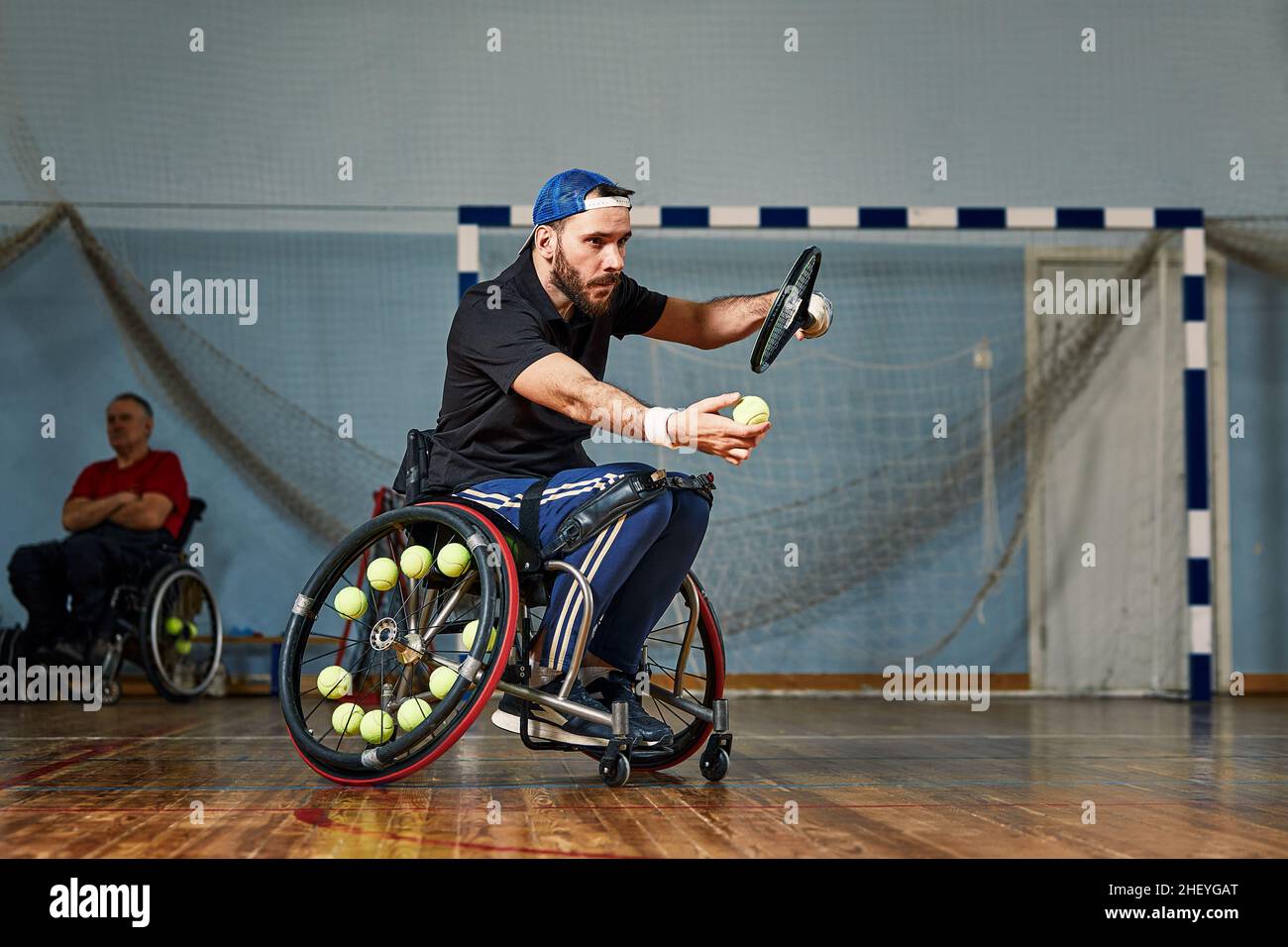 young man with a physical disability playing tennis on wheelchair on ...