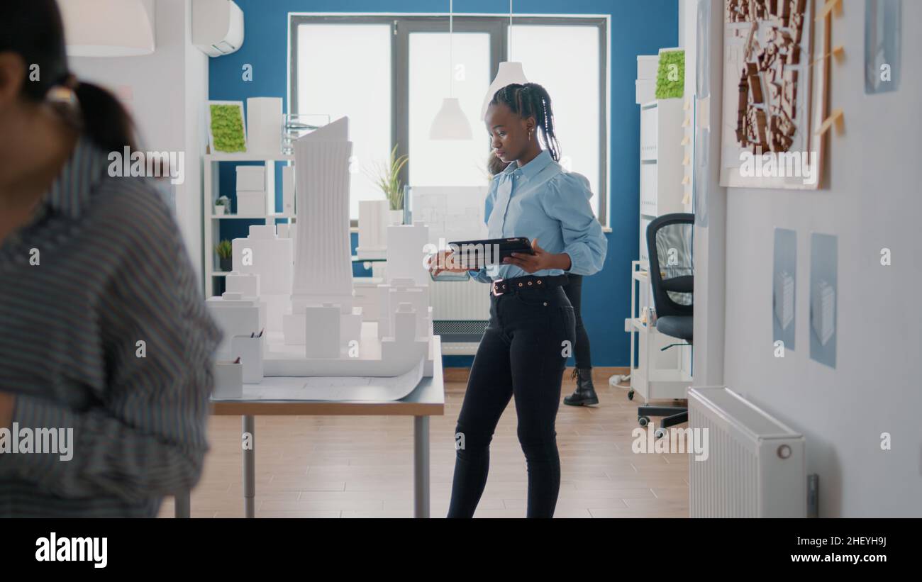 African american woman using digital tablet to design blueprints plan ...