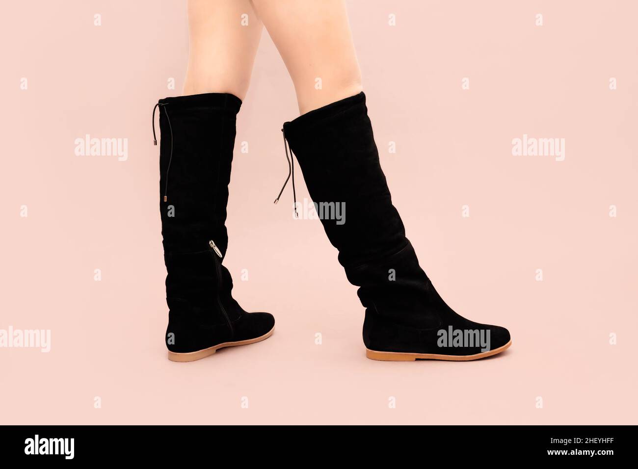 Woman's legs in black long winter suede boots without heels, with flat ...