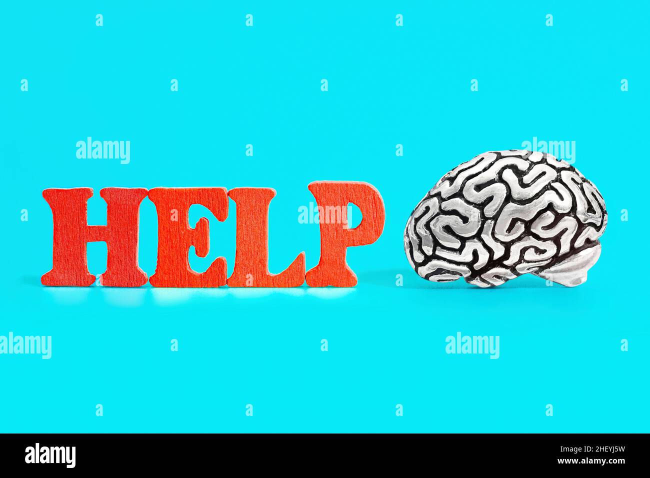 Anatomical copy of a human brain lying by a HELP sign made from red ...