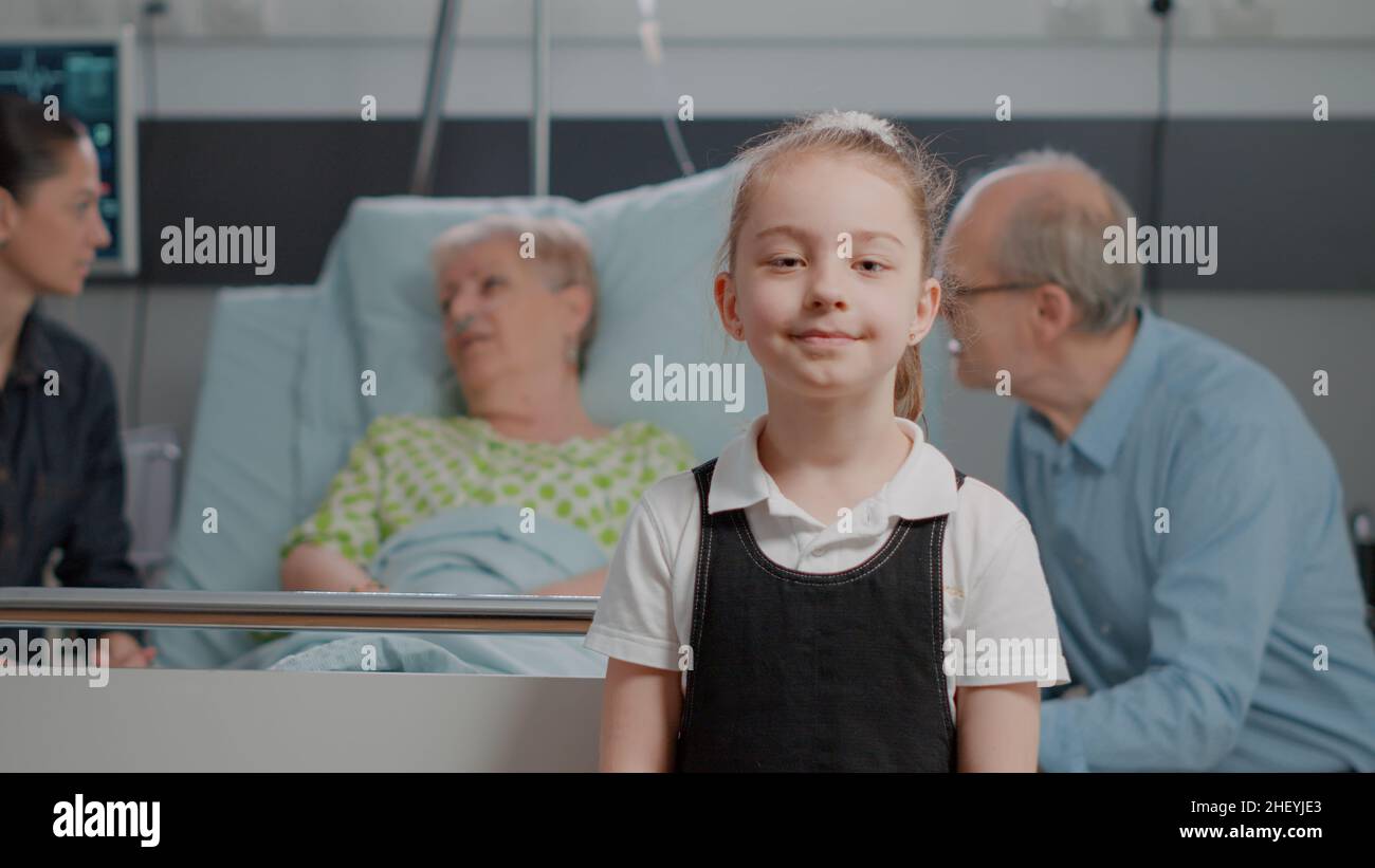 Portrait of young child standing in hospital ward at clinic, visiting ...