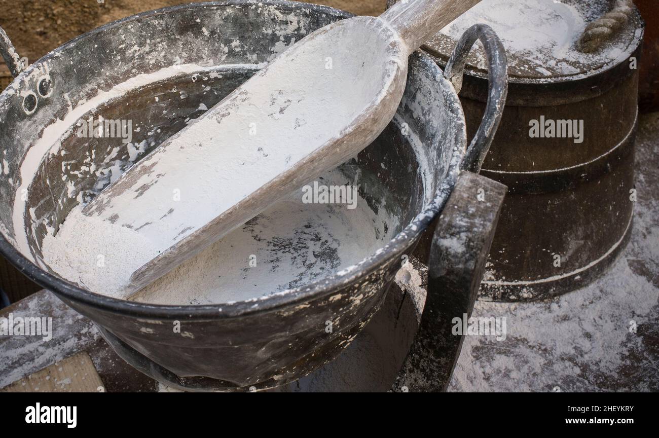 Wooden scoop full of flour at old bakehouse. Manufacturing process in ...