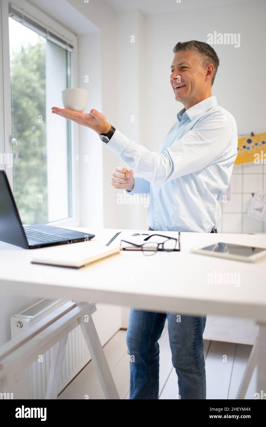 Businessman standing behind bar table with notebook and taking coffee ...