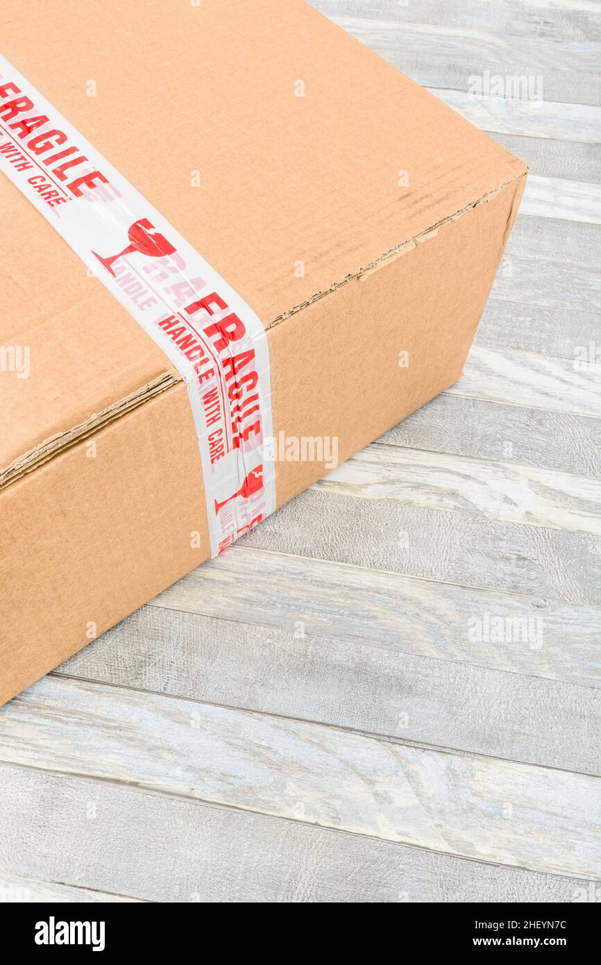 Brown cardboard shipping box with red and white polypropylene plastic 'Fragile Handle with Care ...