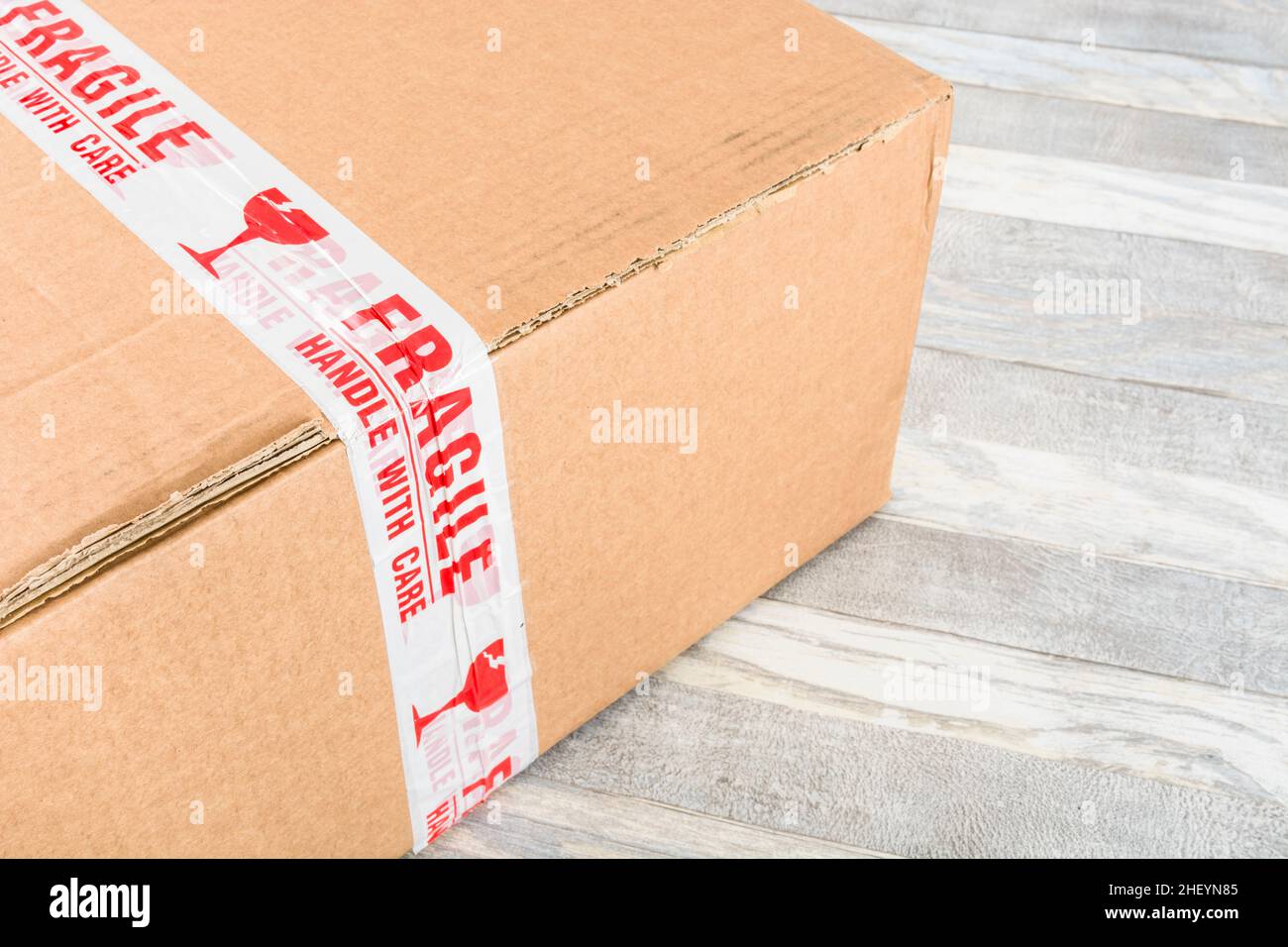 Brown cardboard shipping box with red and white polypropylene plastic 'Fragile Handle with Care ...
