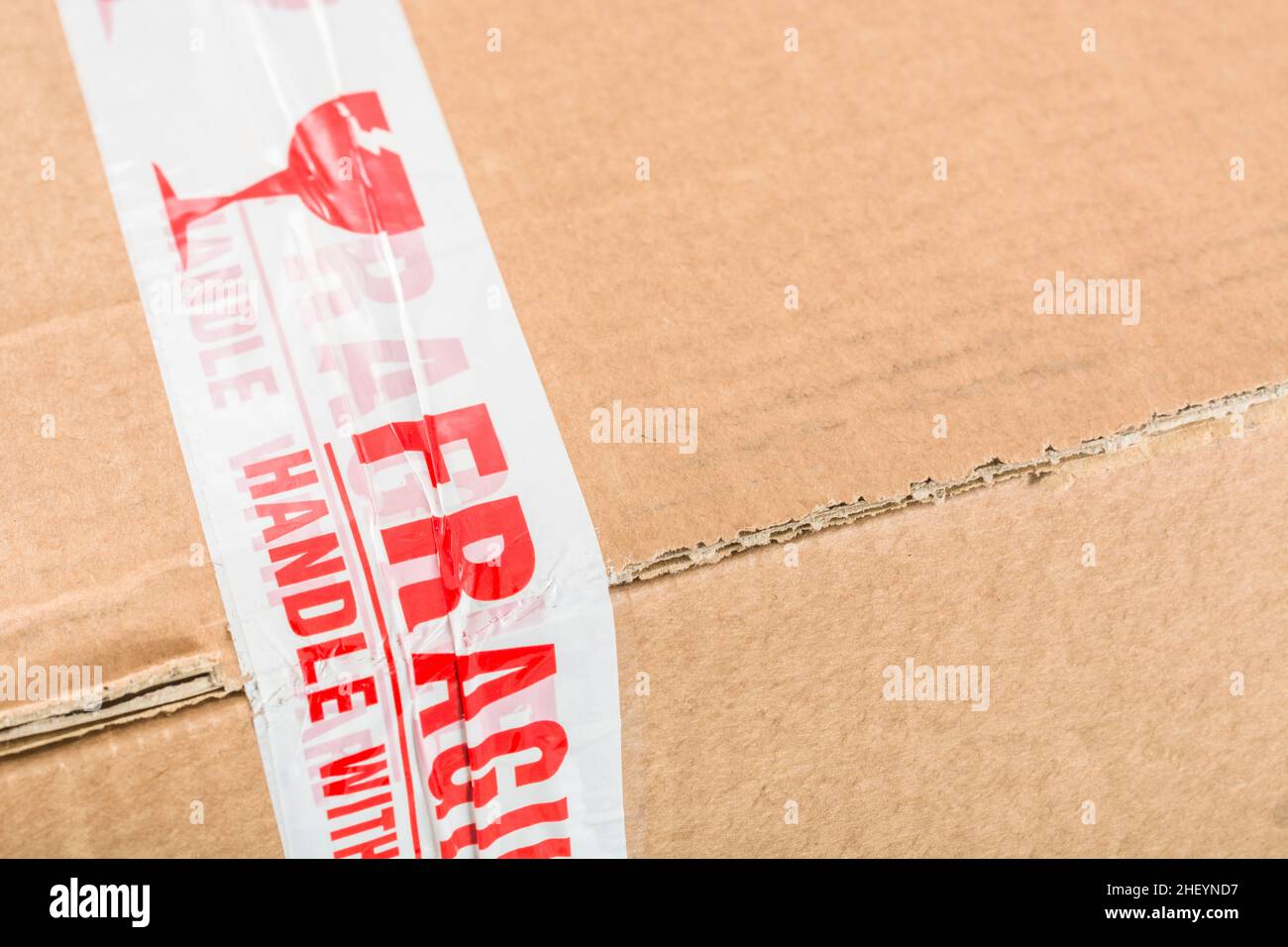 Brown cardboard shipping box with red and white polypropylene plastic 'Fragile Handle with Care ...