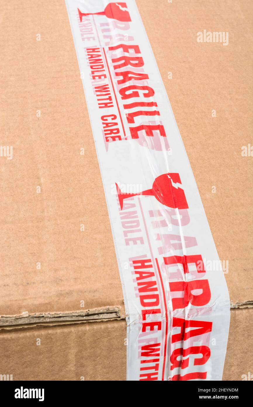 Brown cardboard shipping box with red and white polypropylene plastic 'Fragile Handle with Care ...