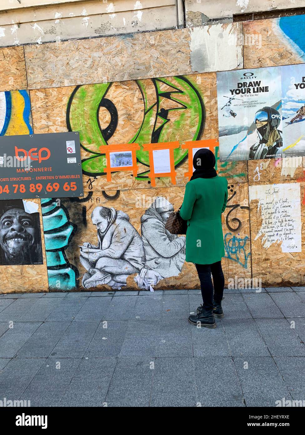 Street view: a passer-by looks at a collage, Lyon, France Stock Photo ...