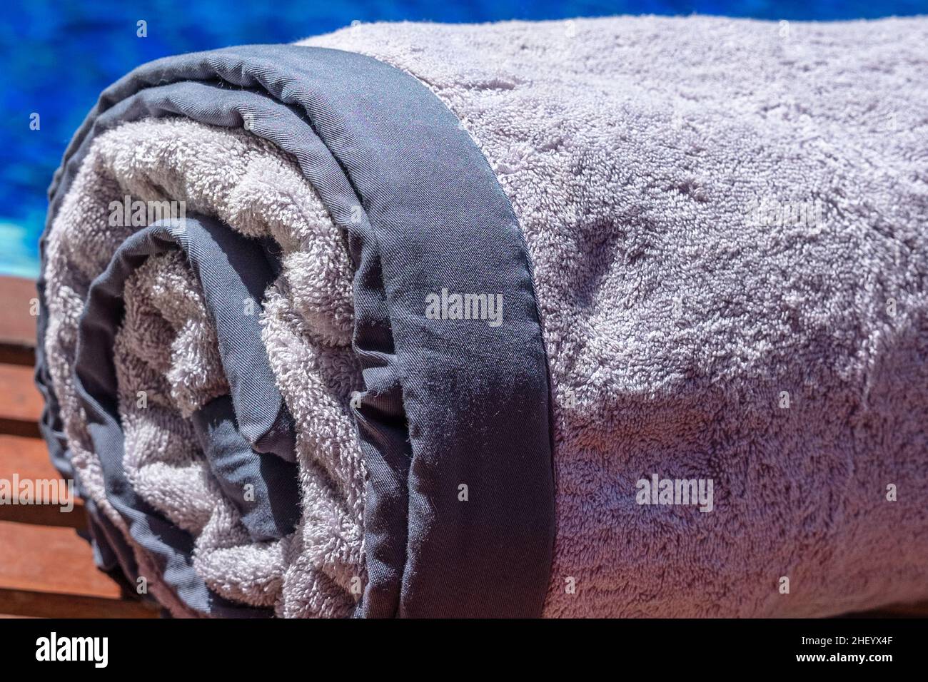 Rolled grey color two side towel near the swimming pool Stock Photo - Alamy