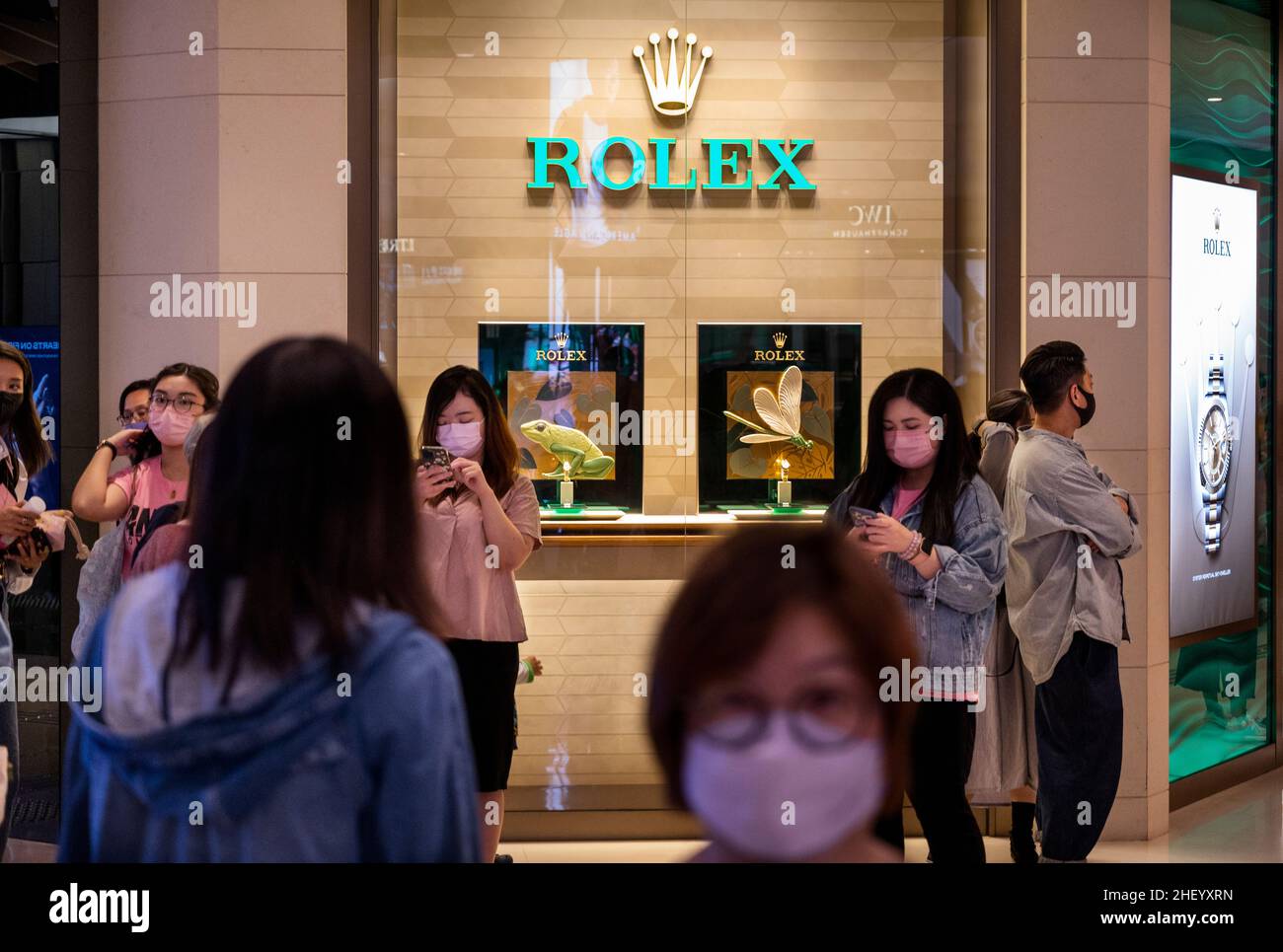 Pedestrians wearing face masks stand in front of the Swiss luxury ...