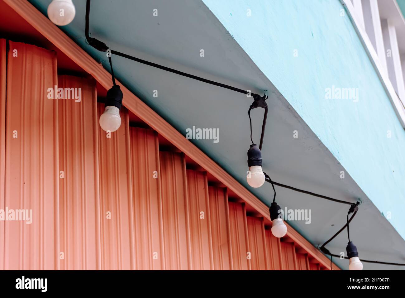 closed store front with pink color boxed rolling door and the string ...