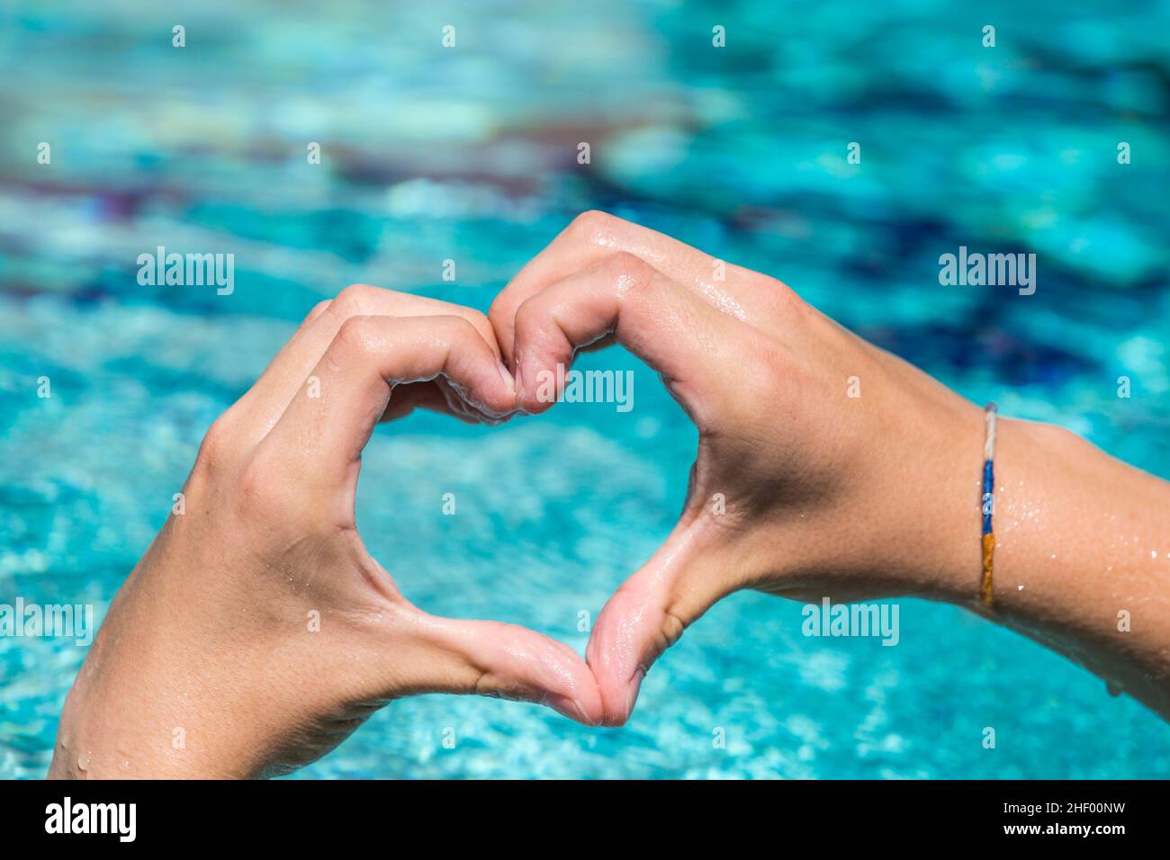 young man shows love sign with heart shape formed by hands Stock Photo ...
