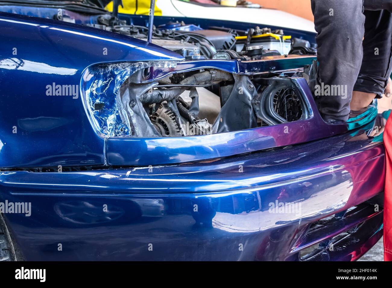 man mechanic fixing and repairing the blue car with unmounted parts at ...