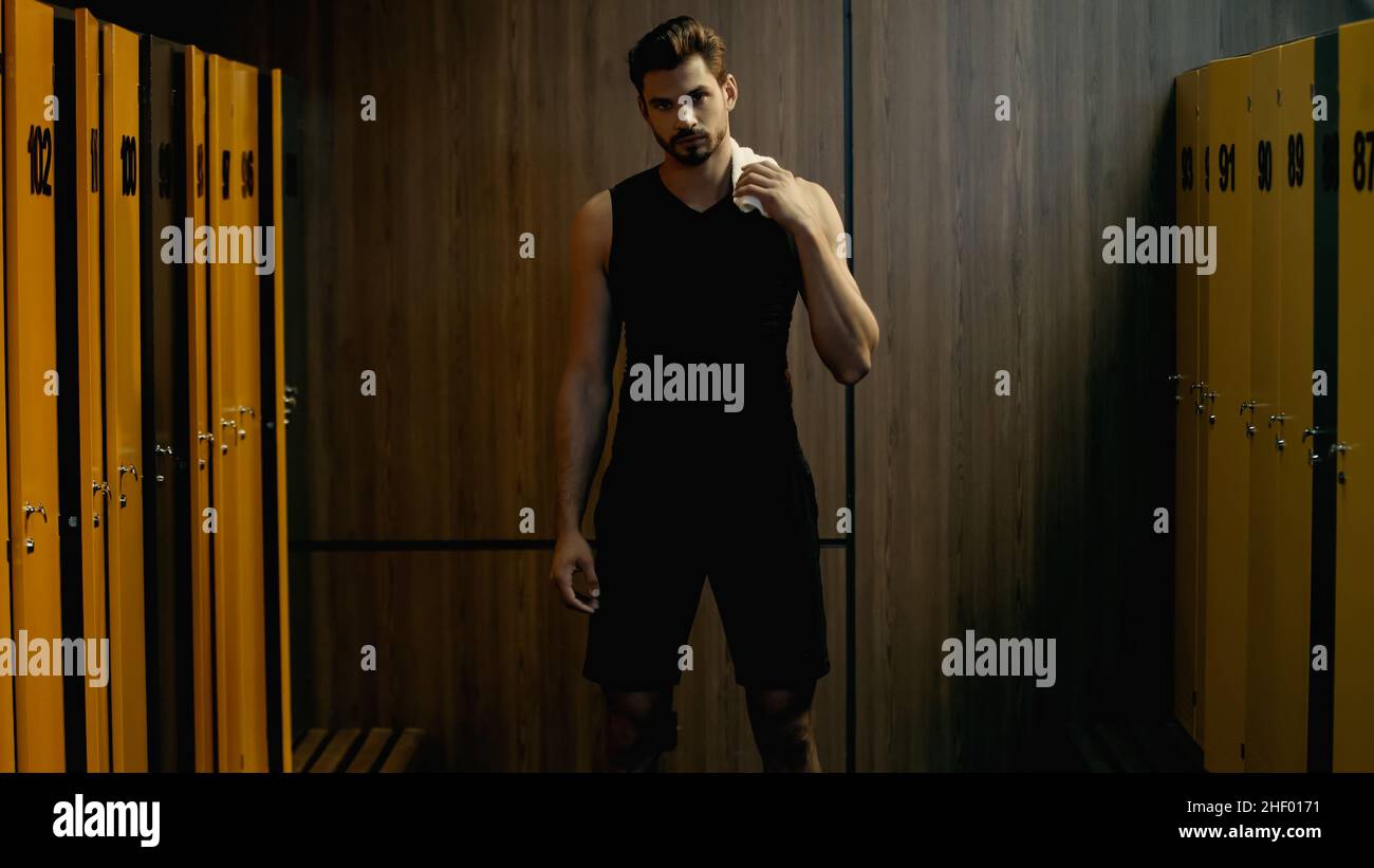 confident sportsman standing with towel in locker room Stock Photo - Alamy