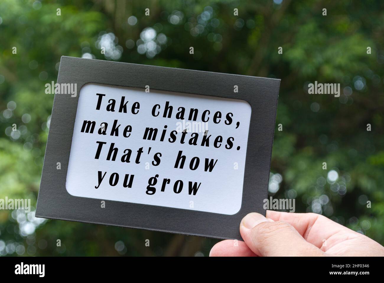 Motivational and inspirational quote on hands holding framed paper with ...