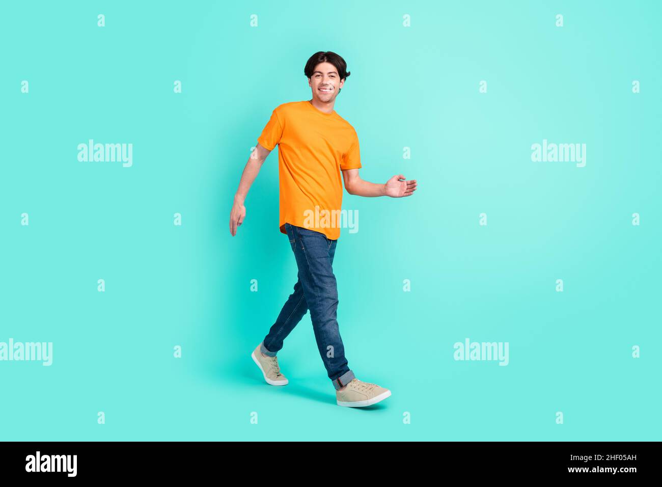 Full Body Photo Of Funny Brown Hair Young Guy Go Give Hand Wear T Shirt Jeans Sneakers Isolated