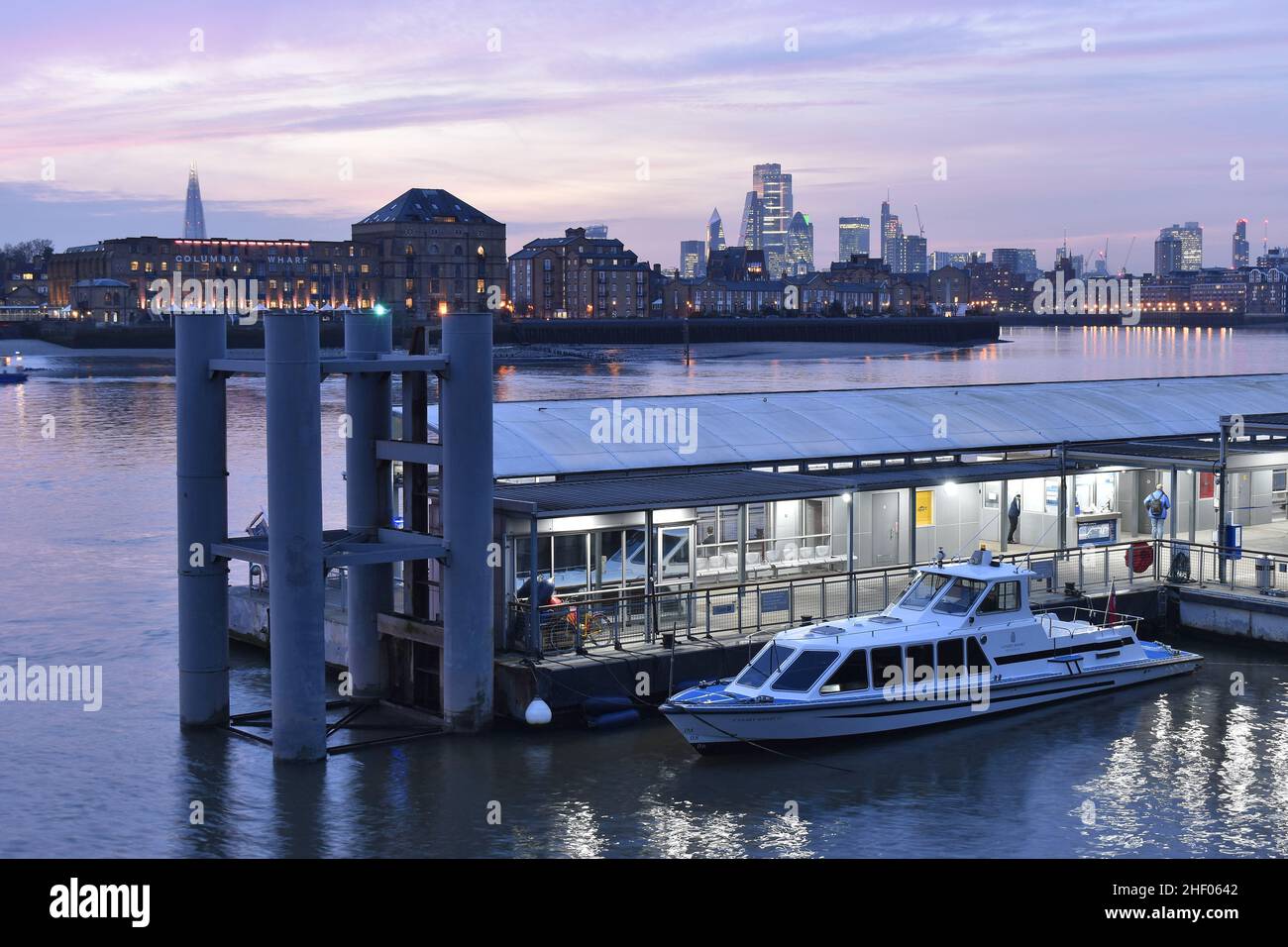 Thames Clippers - Canary Wharf Pier at dusk with City of London ...