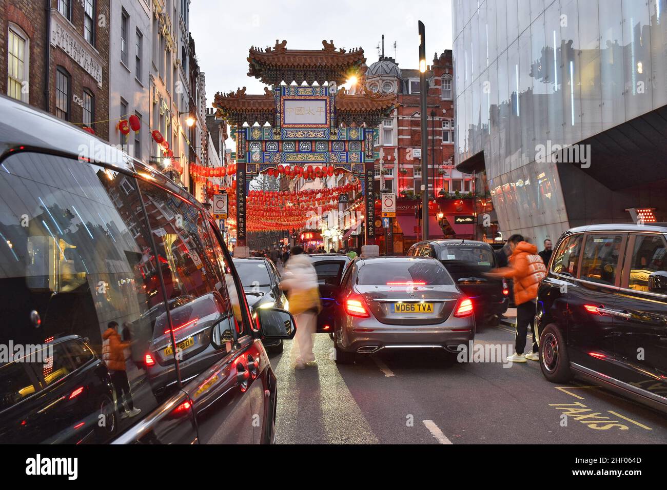 Glass facade of modern W Hotel Leicester Square and street of Chinatown with traditional ...