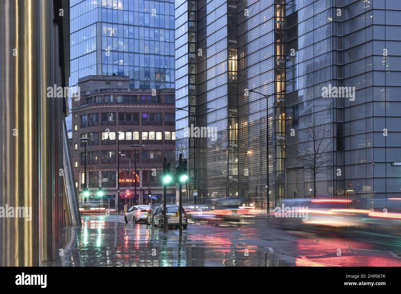 Modern properties with Heron Tower glass building, rainy street at dusk ...