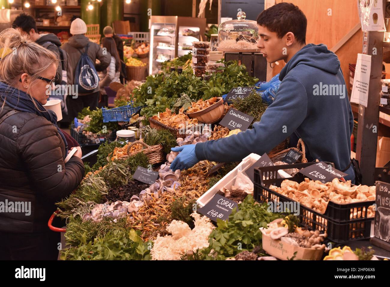 Shopkeeper at Borough market selling varieties of mushrooms, Southwark ...