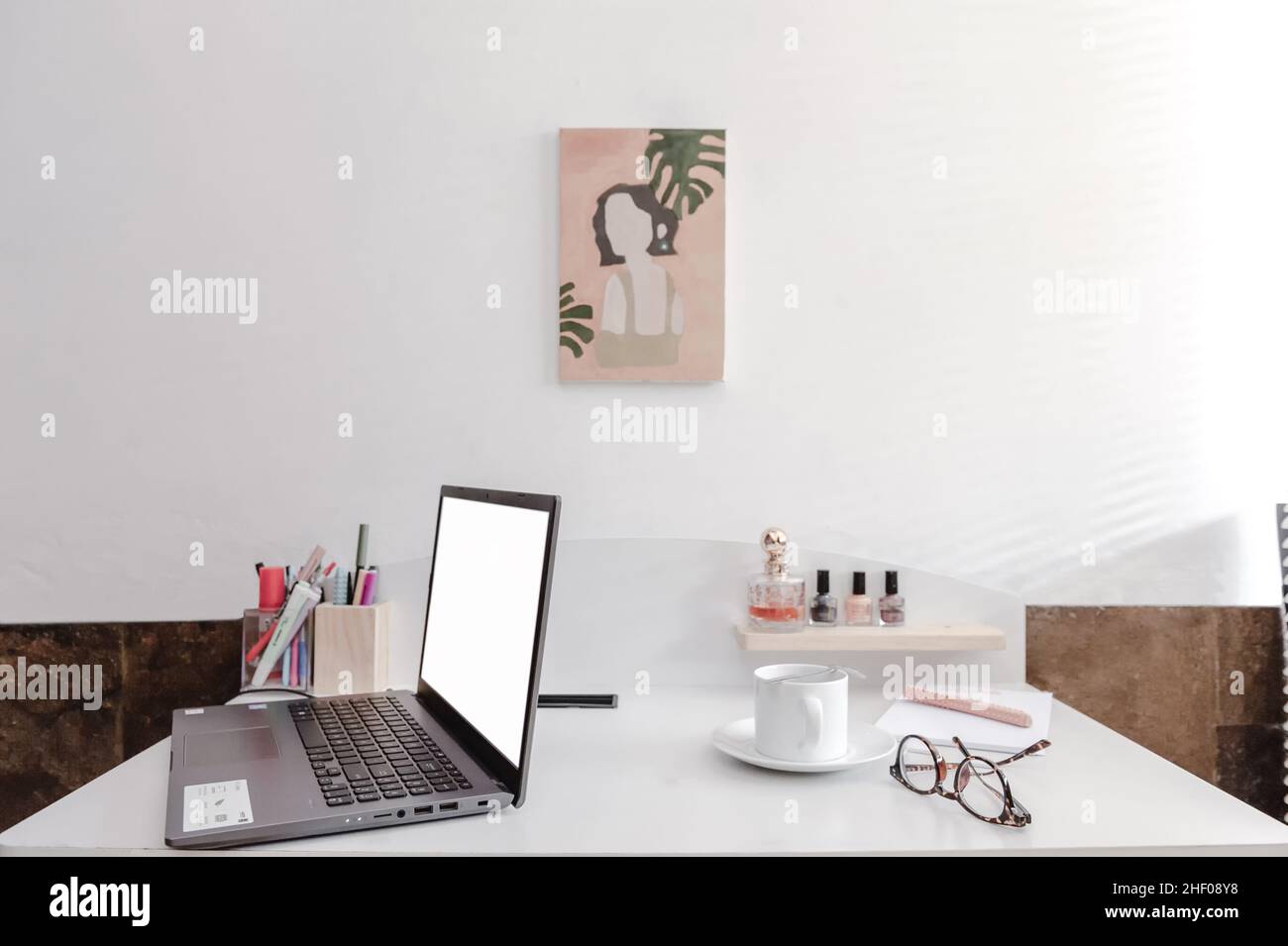 Laptop with white screen on busy table Stock Photo - Alamy
