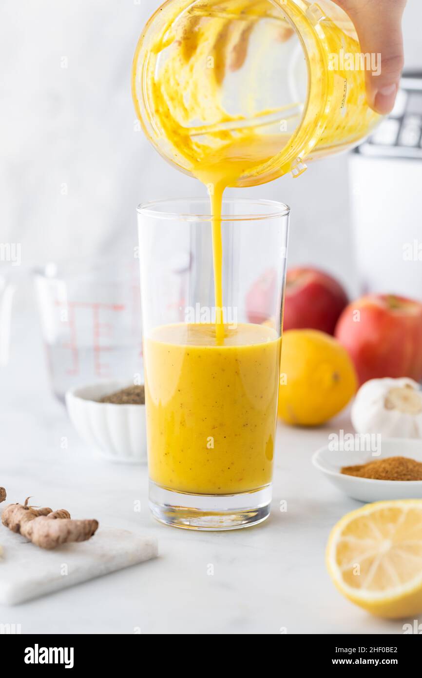 Pouring a detox smoothie into a tall glass from a the blender cup Stock ...