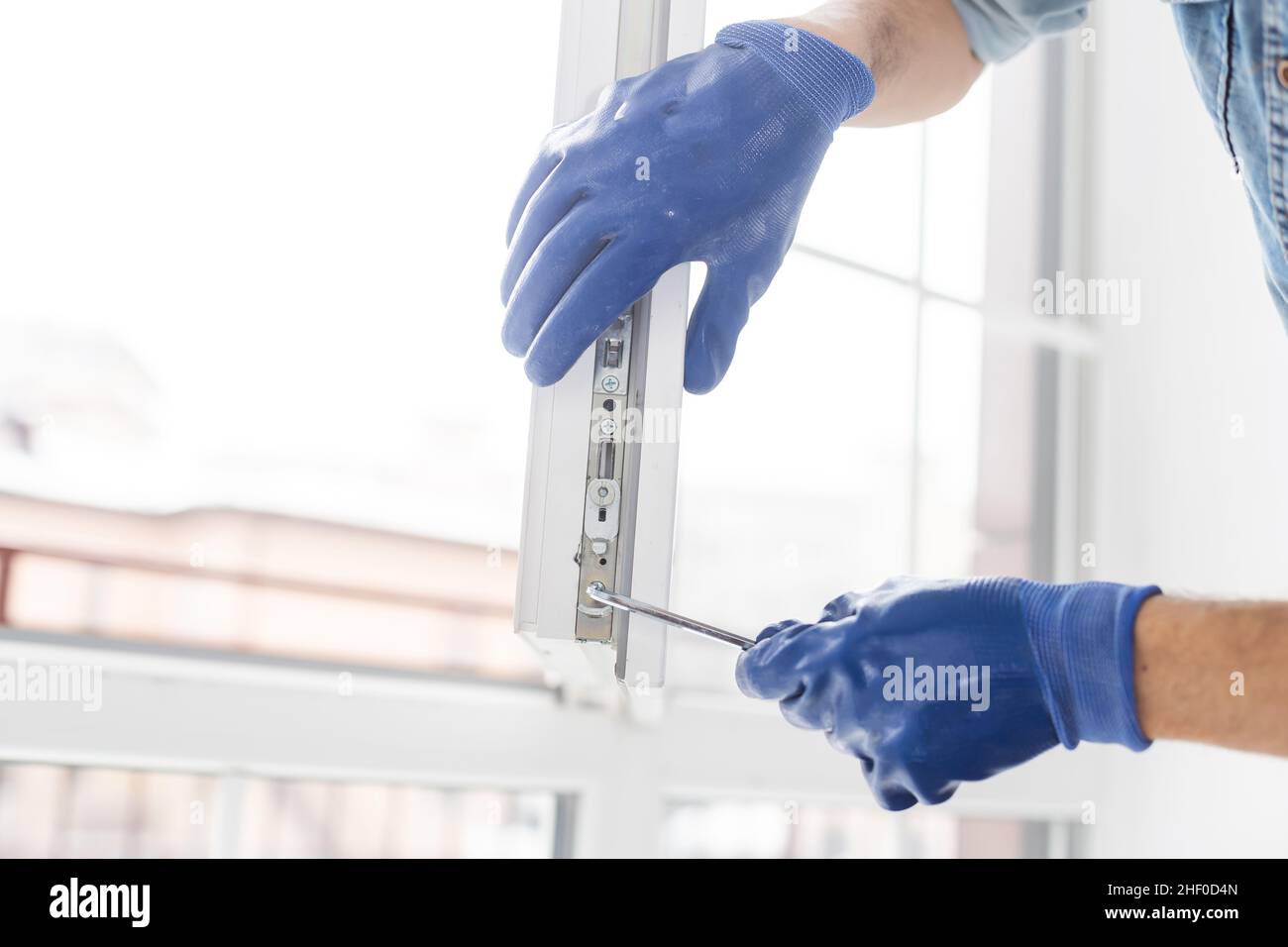 A worker in gloves checks the lock in a new plastic door Stock Photo ...