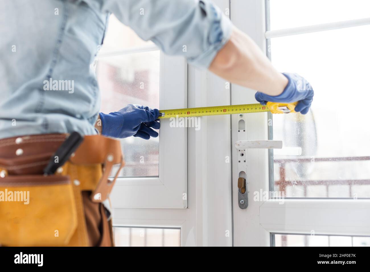 handsome young man installing bay window in a new house construction ...