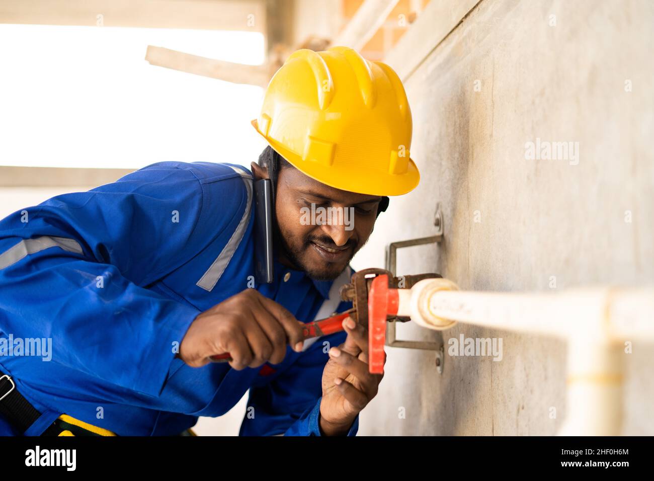 Plumber or repairman talking on mobile phone with colleague while ...