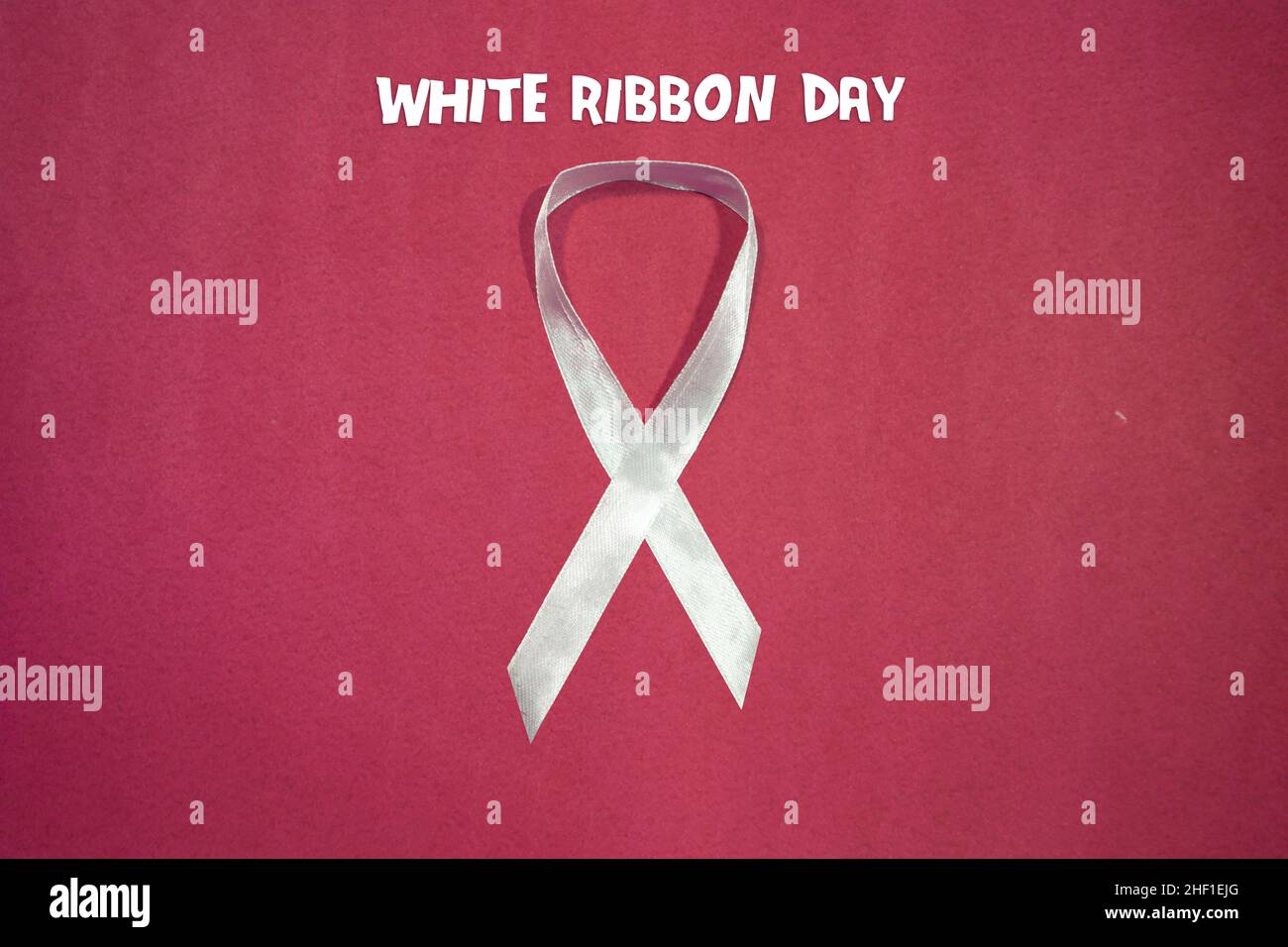 White Ribbon Day Symbol, isolated on Red background Stock Photo - Alamy