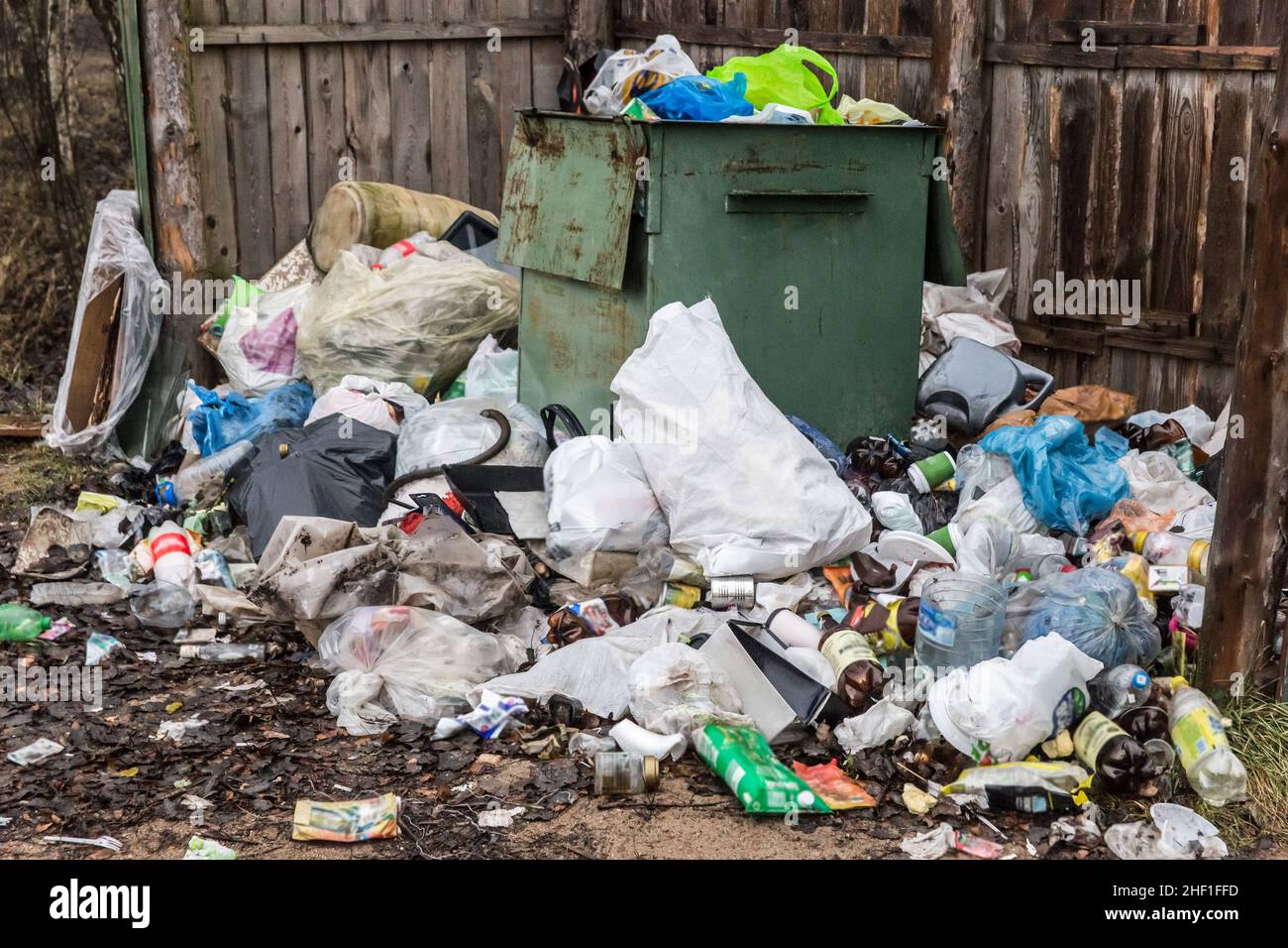 Waste glass and plastic bottles and bags at the tank of the container ...