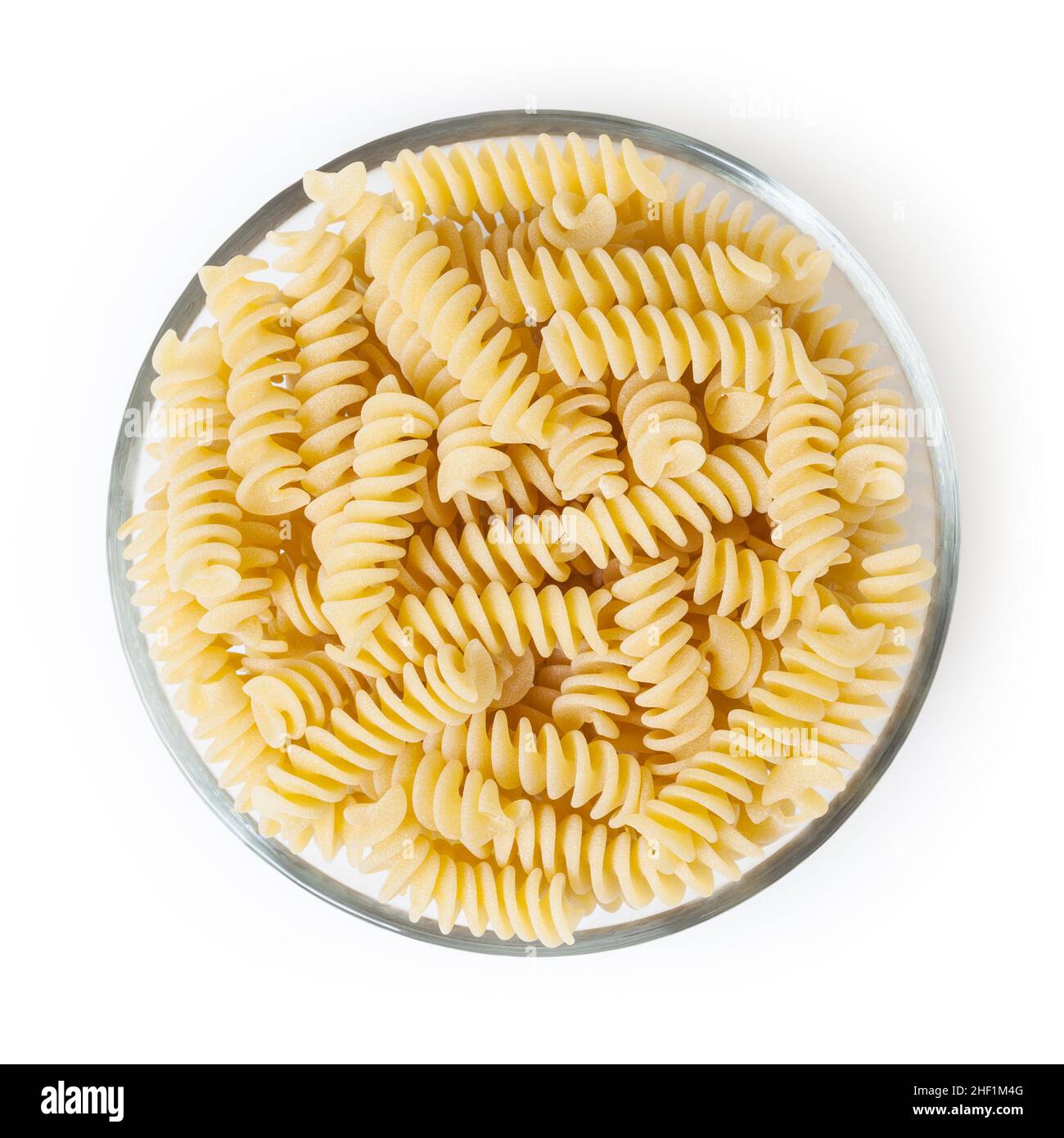 Uncooked fusilli pasta in glass bowl isolated on white background with ...