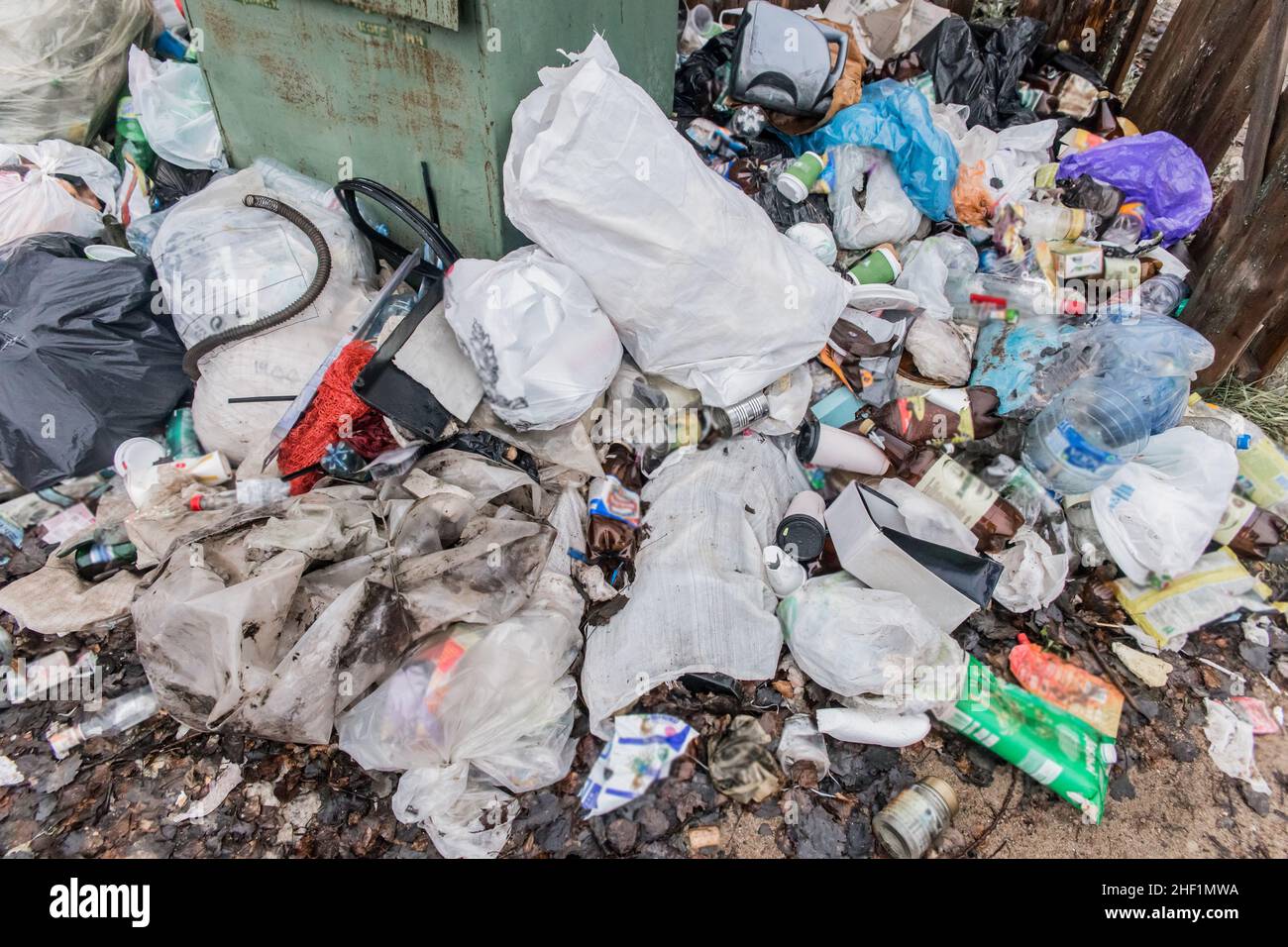 Waste glass and plastic bottles and bags at the tank of the container ...