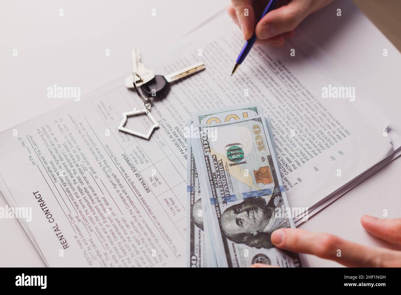 Man signing real estate contract, making a deal with cash dollar money ...