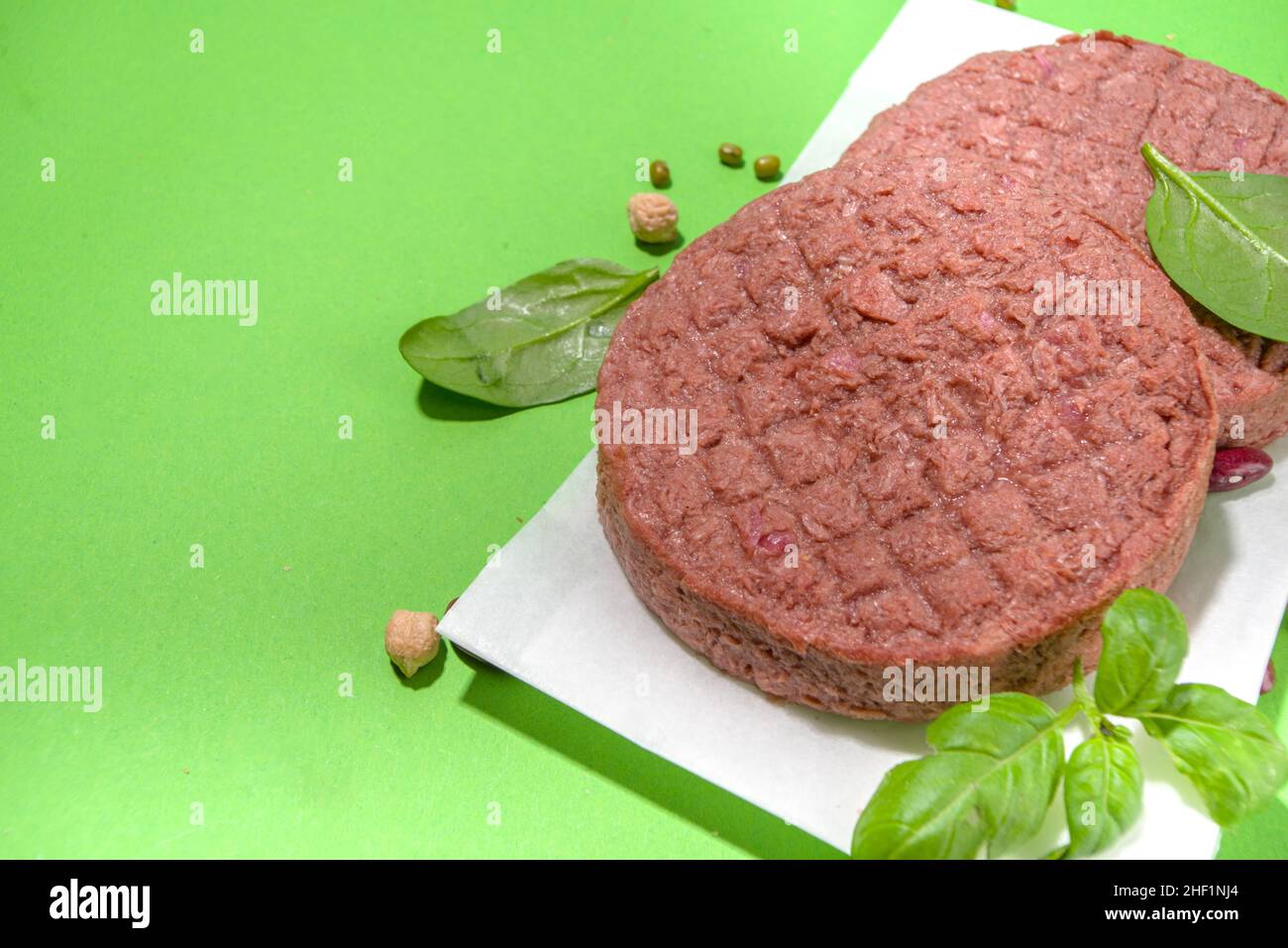 Lab-grown or plant based burger cutlet, minced meat steaks over green ...