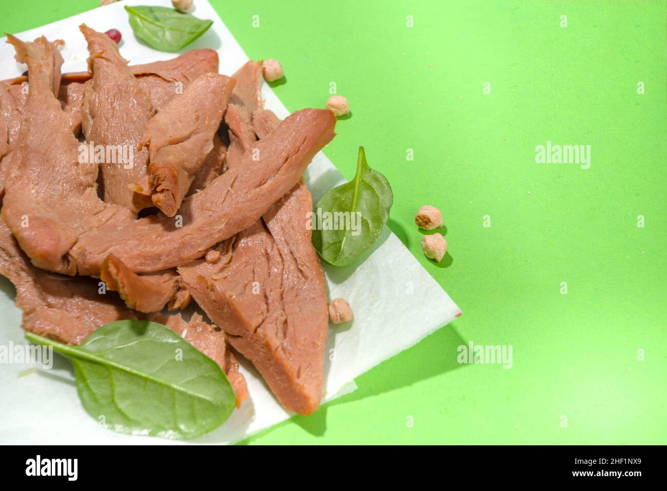 Lab-grown or plant based white meat steaks strips over green background ...