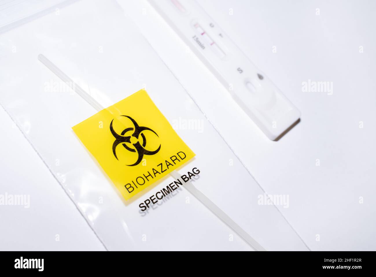 Positive at-home covid self-test with swab in biohazard plastic bag on ...