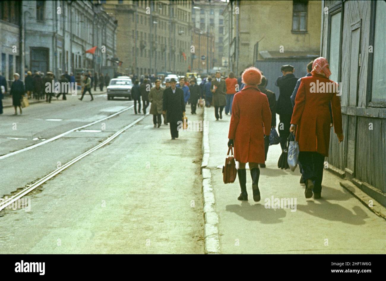 Street scene. Two women in red walk along the sidewalk. Moscow, USSR ...