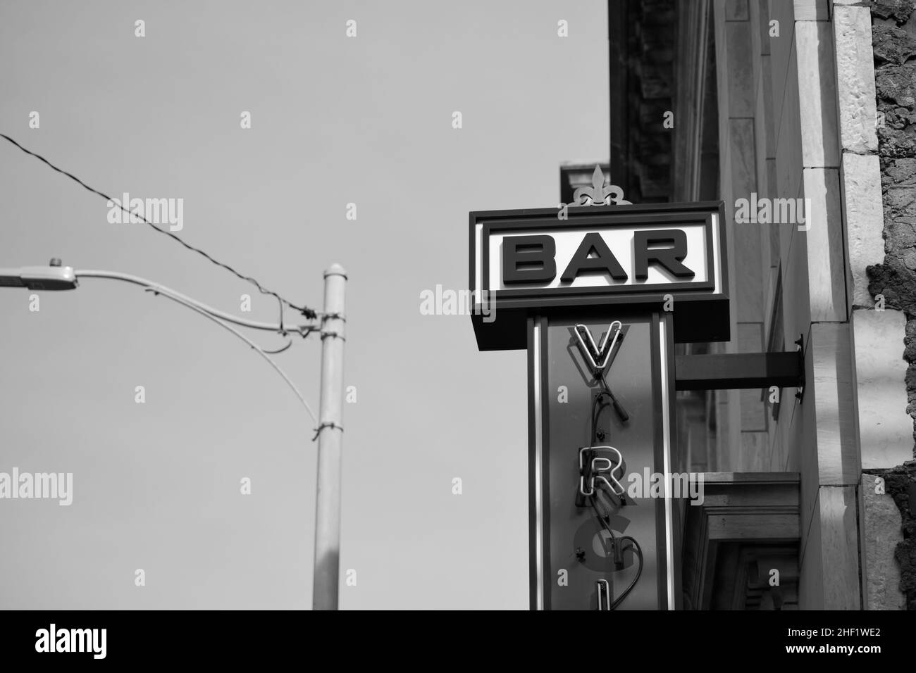 A bar sign hangs high above a sidewalk Stock Photo - Alamy