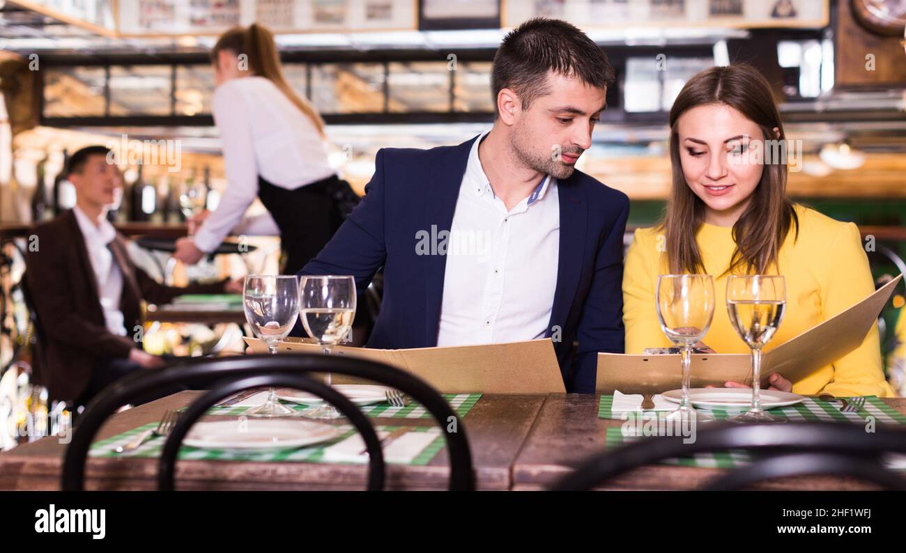 Female and male are looking in menu for order dinner Stock Photo - Alamy