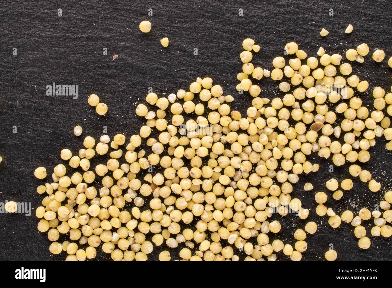 Uncooked organic millet groats on a slate stone, macro, top view Stock ...