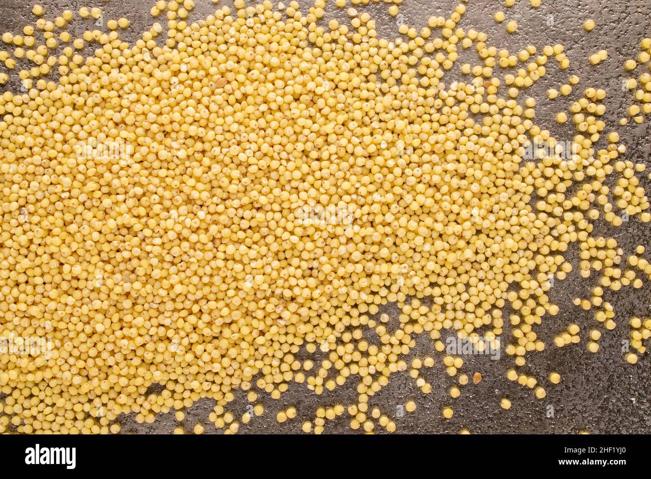 Raw organic millet groats on a metal tray, macro, top view Stock Photo ...
