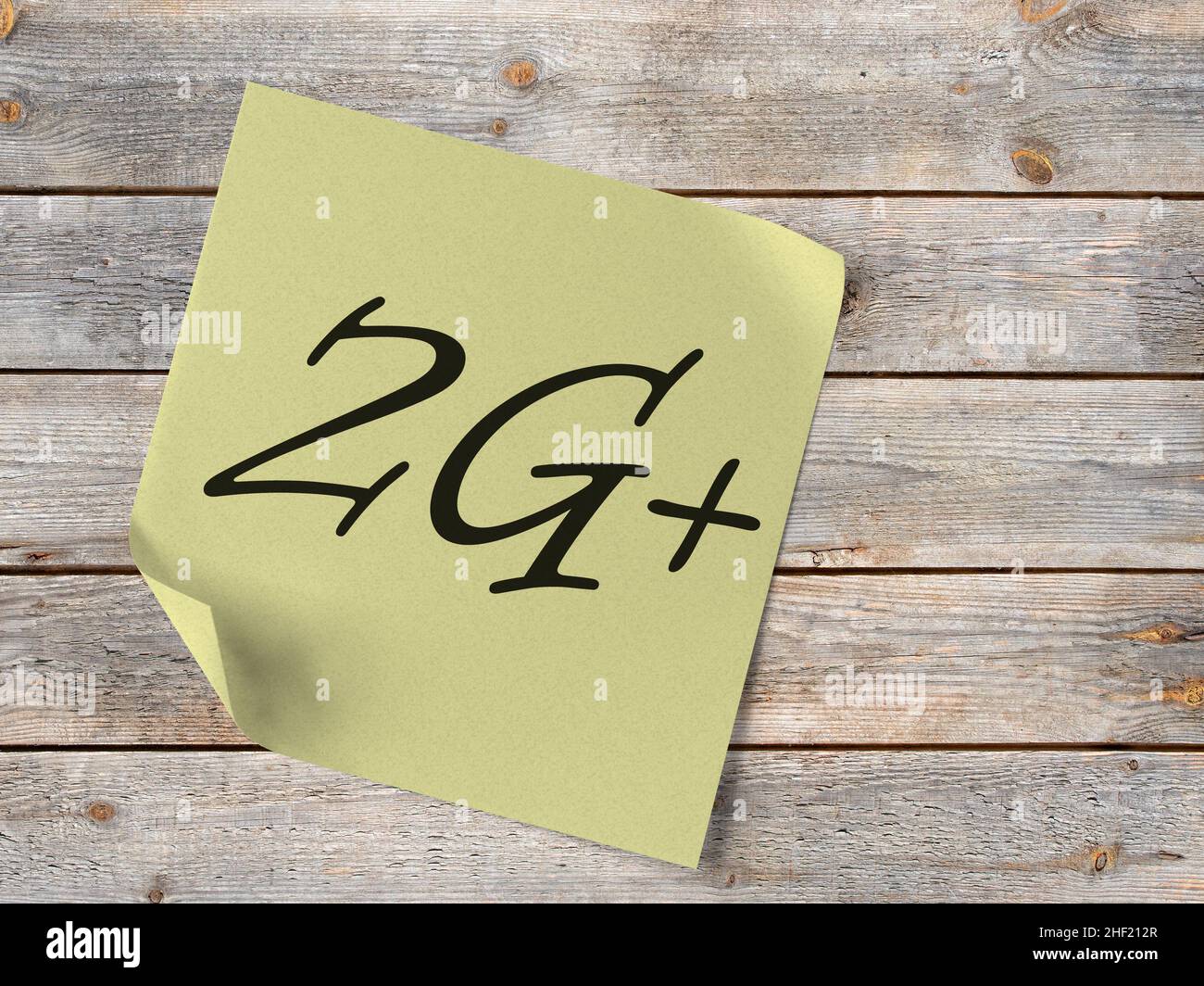 Sticky note with the inscription 2G+ on a wooden wall Stock Photo - Alamy