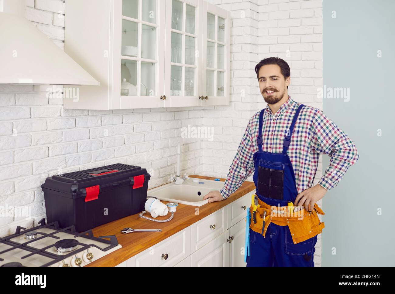 Portrait of happy plumber pose in client home Stock Photo - Alamy