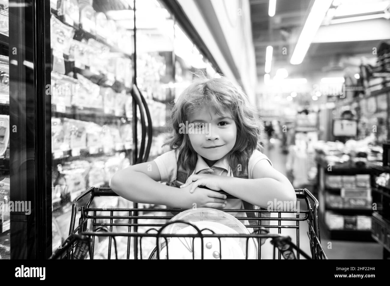 Little customer child at grocery or supermarket with goods in shopping ...