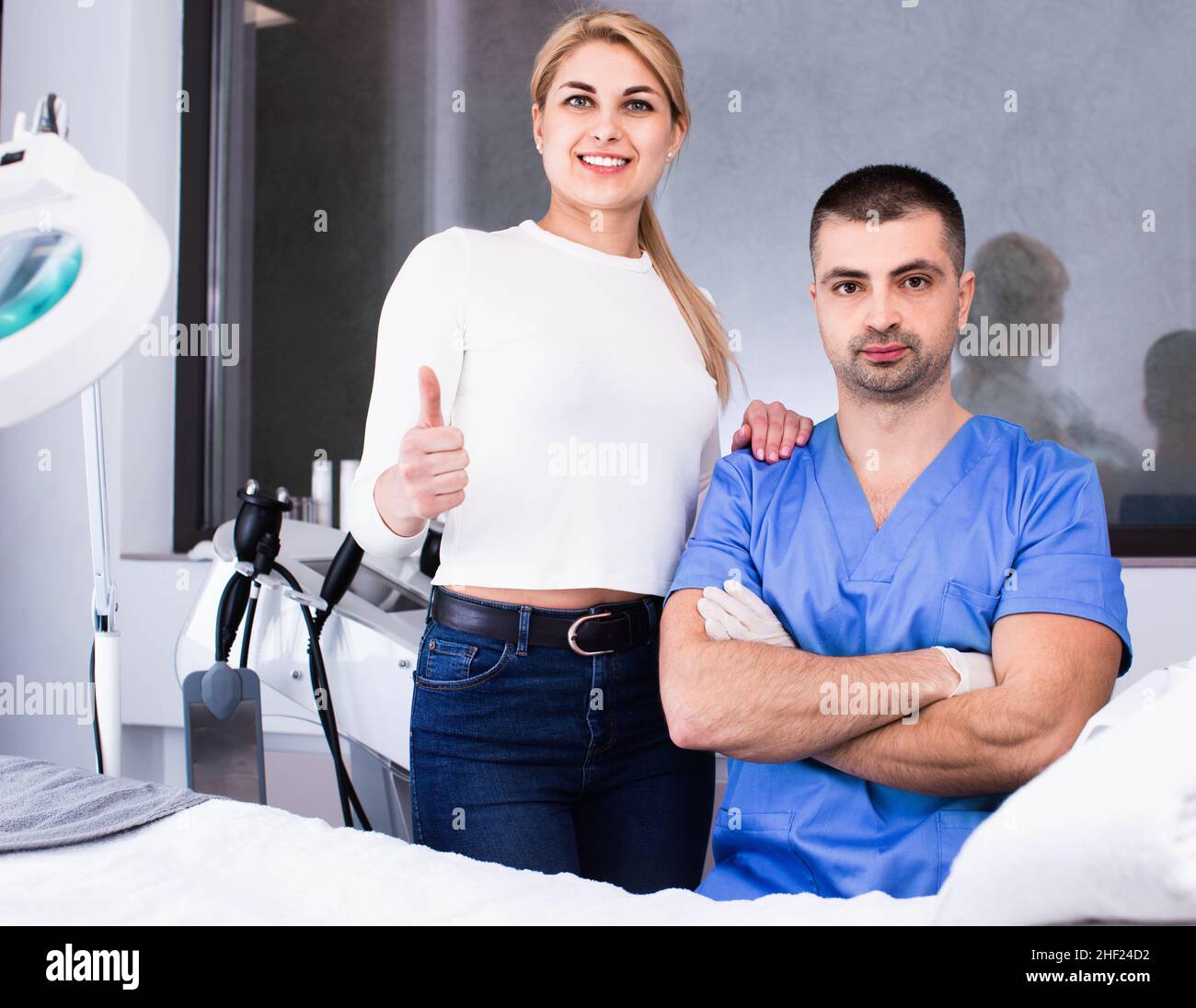 Portrait of professional beautician and female client satisfied with ...