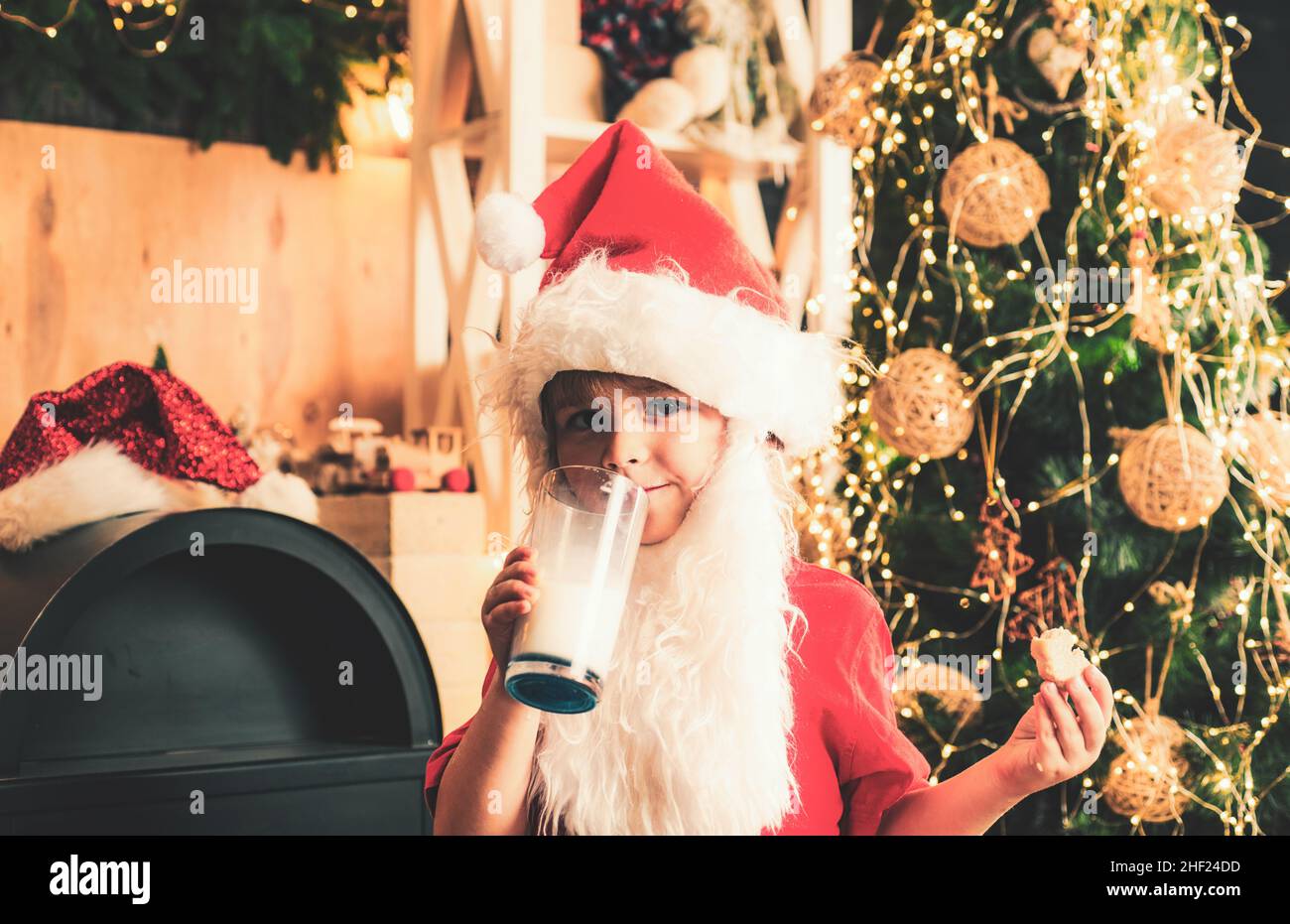 Happy kids Santa Claus with glass of milk and cookie. Christmas food ...